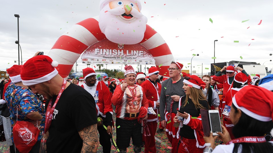 Participants pass under the finish line arch
